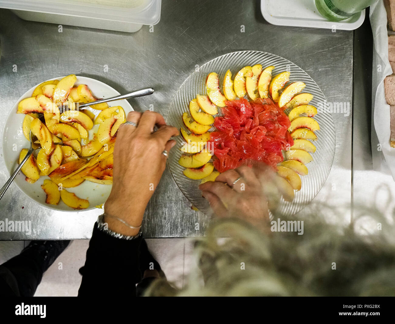 woman Chef preparing a salmon marinated in vodka with fruits and pepper ...