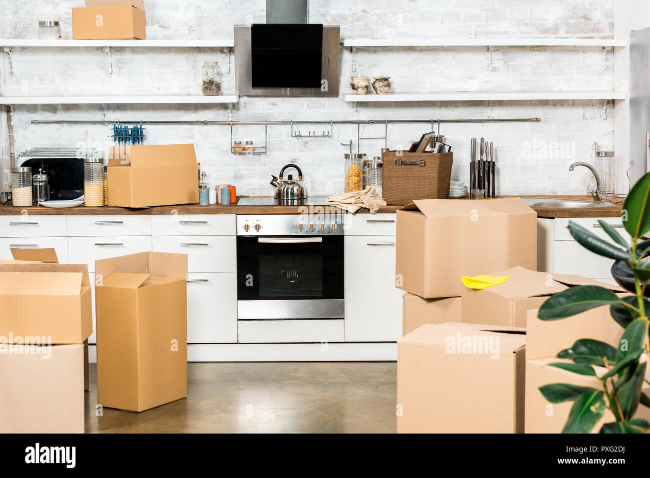 interior of modern kitchen with cardboard boxes during relocation at ...