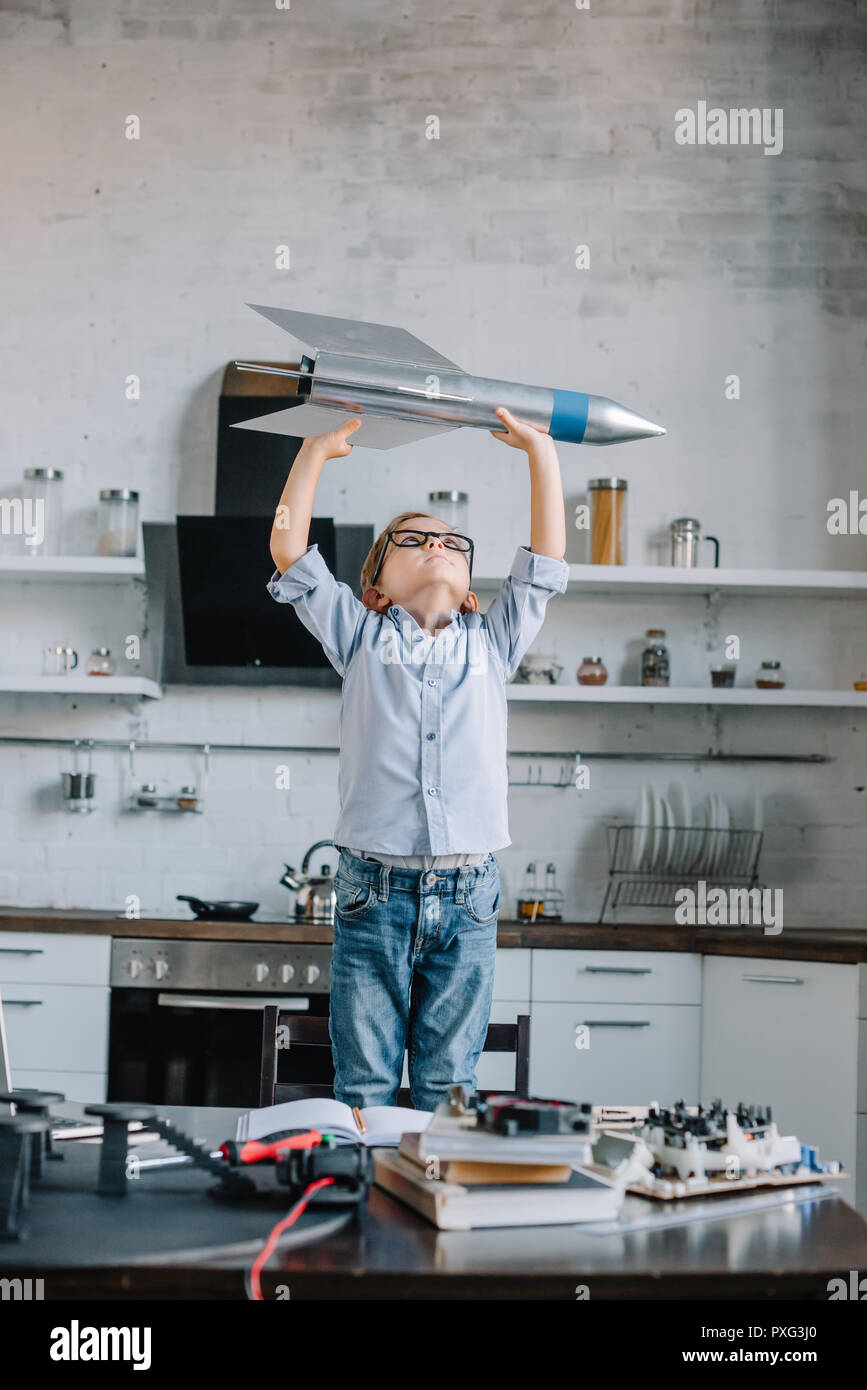 adorable boy holding rocket model in kitchen on weekend Stock Photo - Alamy