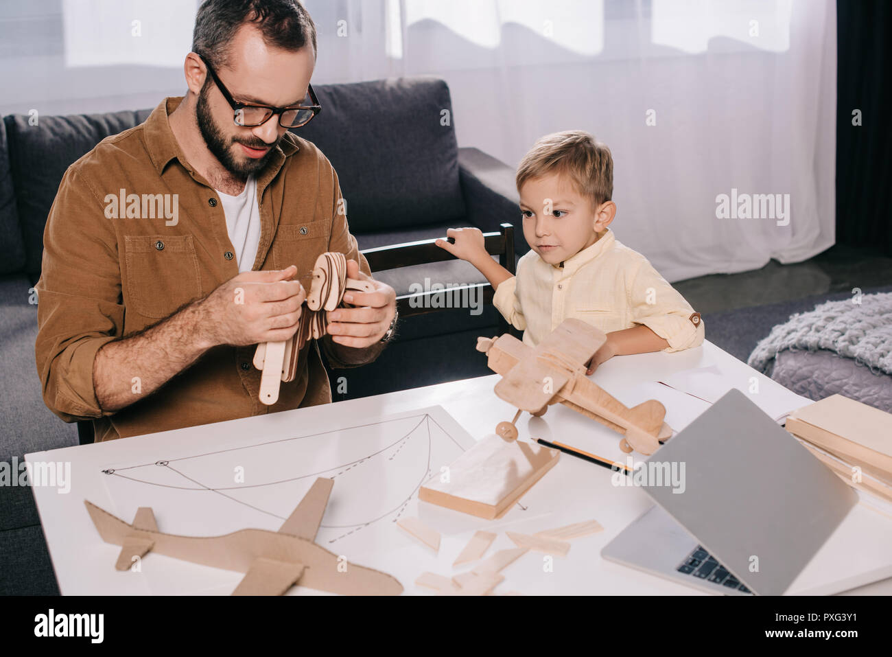 happy father and son modeling wooden plane at home Stock Photo - Alamy