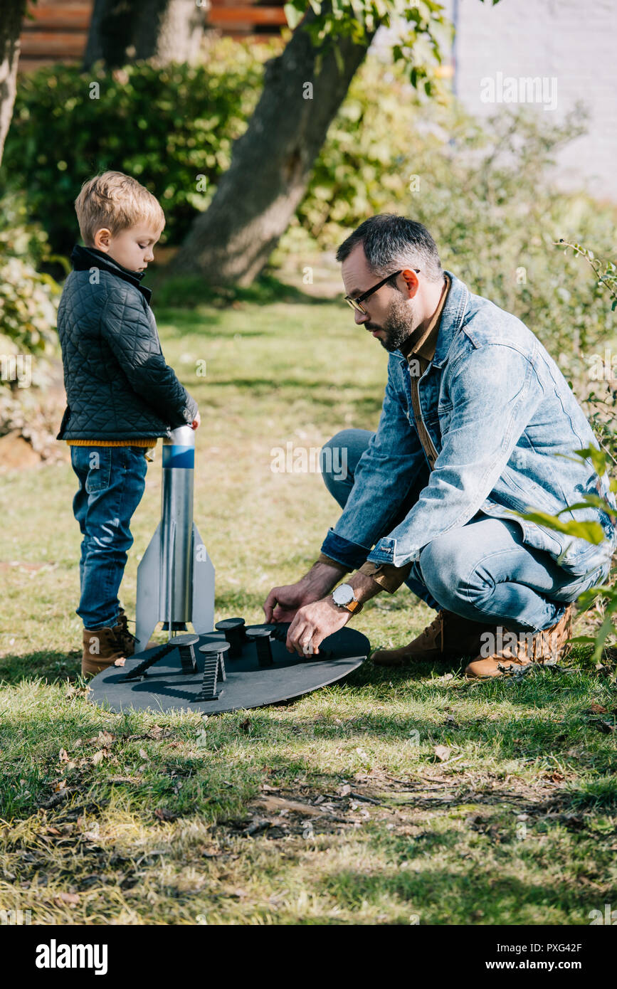 side view of father and little son launching model rocket outdoor Stock ...