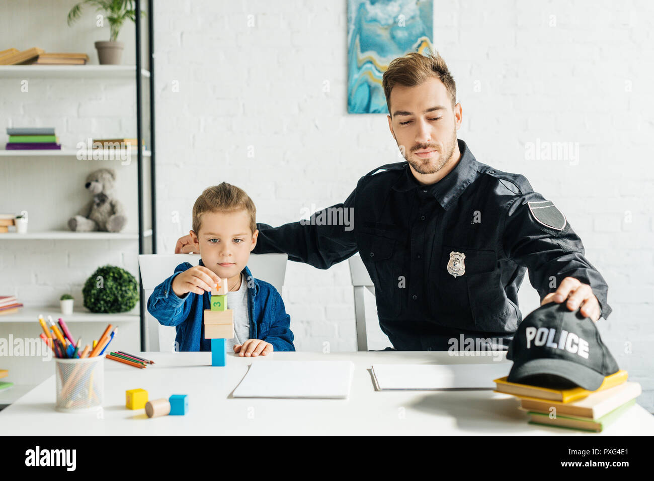 handsome young father in police uniform and son playing together at ...