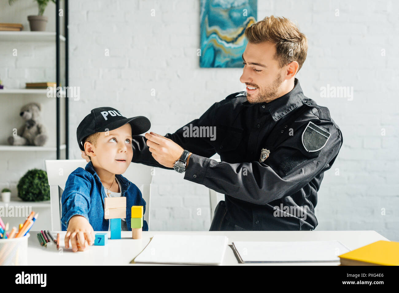 happy young father in police uniform and son spending time together at ...