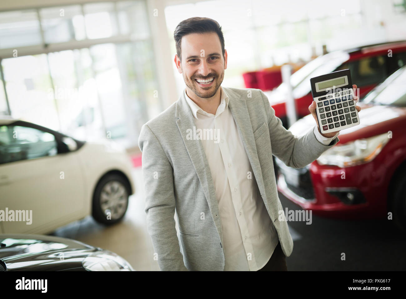 Car salesman calculating a price at the dealership office Stock Photo ...