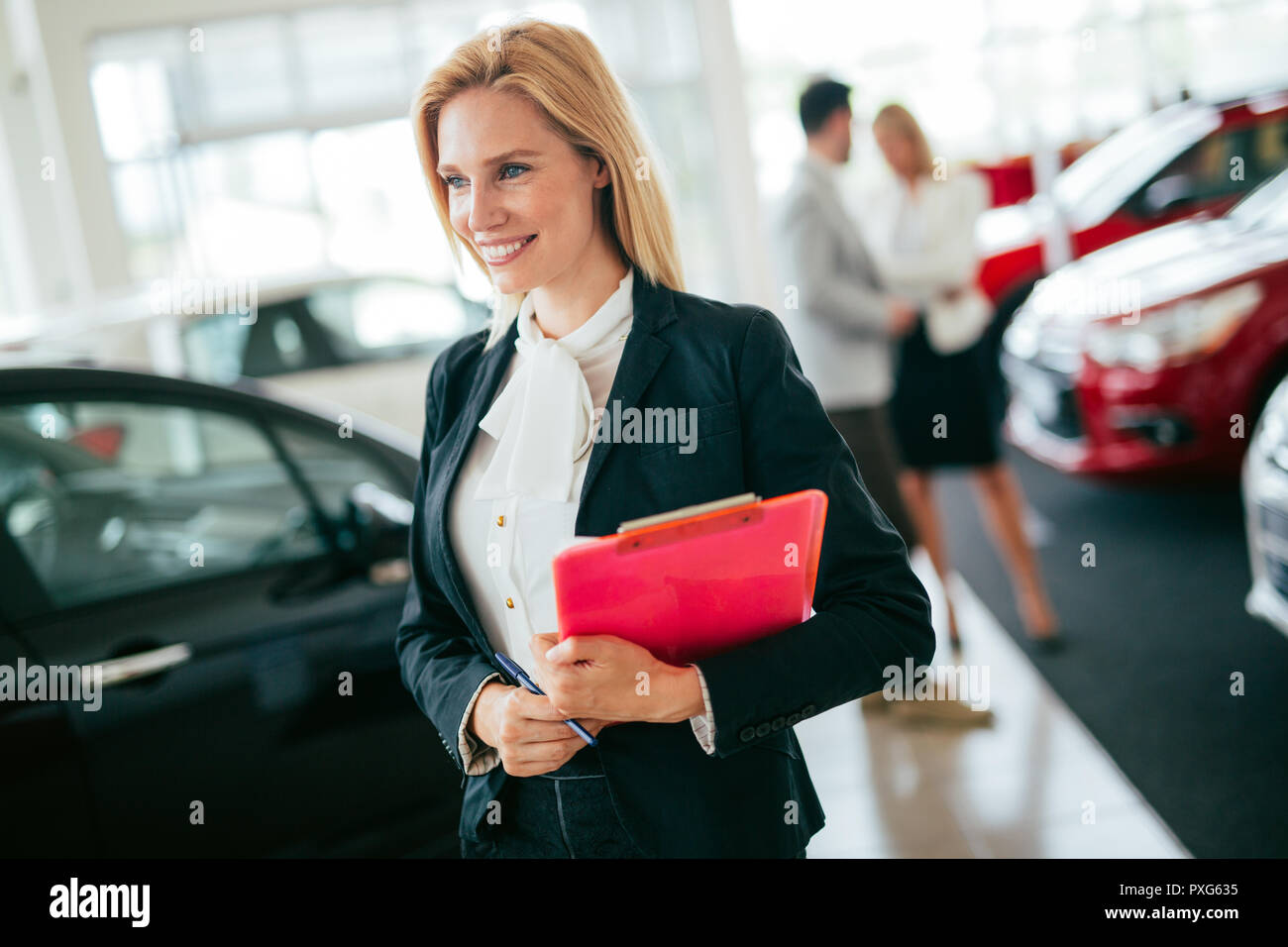 Professional salesperson during work with customer at car dealership ...