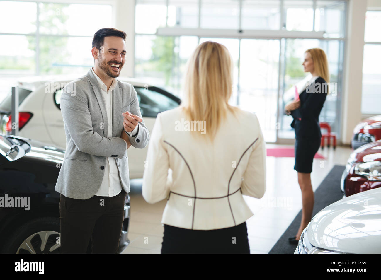 Dealer showing a new car model to the potential customer Stock Photo ...
