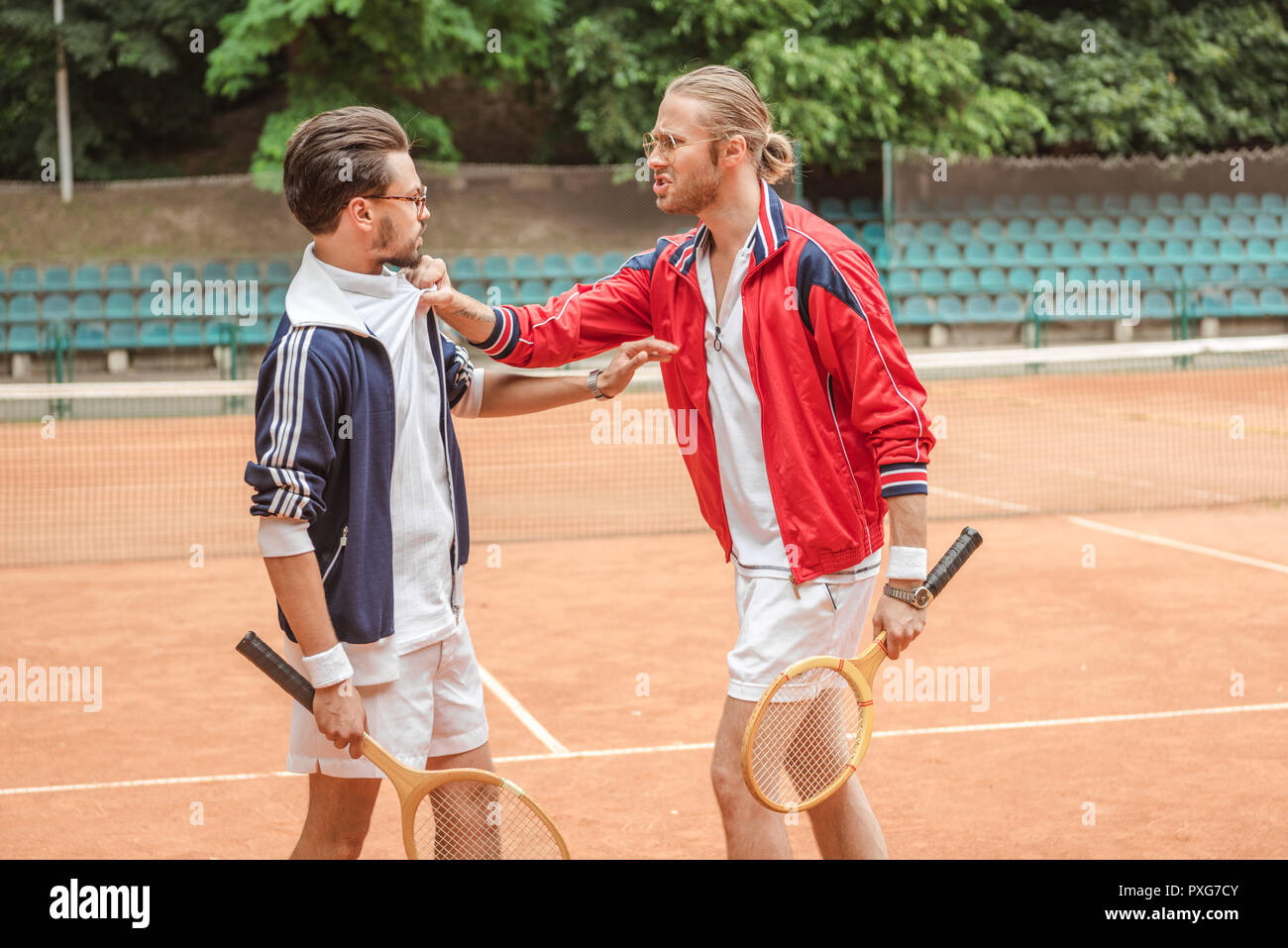 angry sportsmen with wooden rackets conflicting on tennis court Stock ...