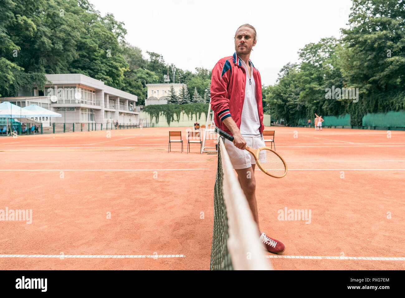 selective focus of handsome tennis player with racket standing at ...