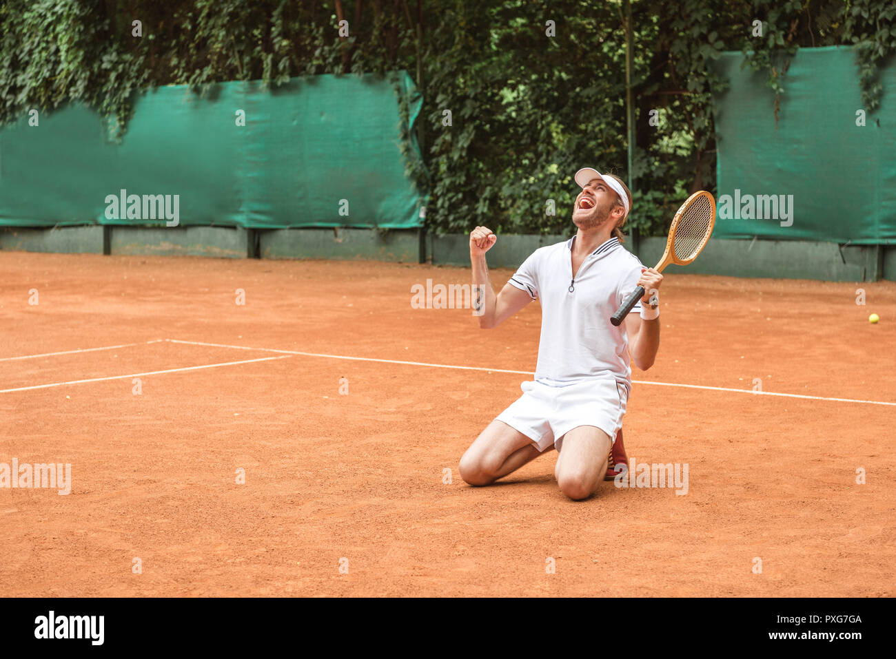 blond winner with racket celebrating and kneeling on tennis court Stock ...