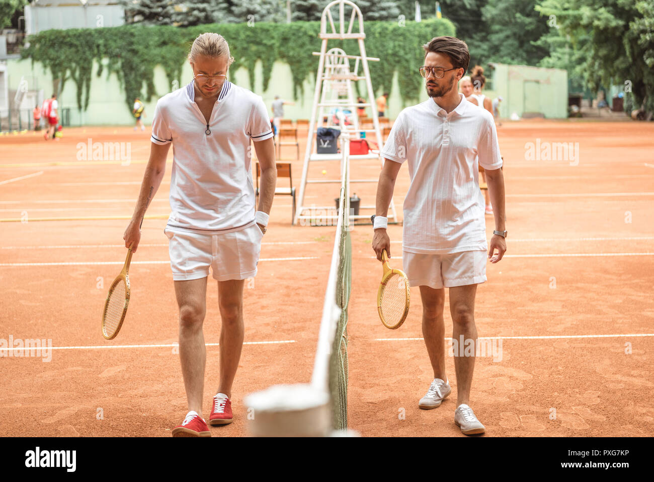tennis players with wooden rackets walking near net on court Stock ...
