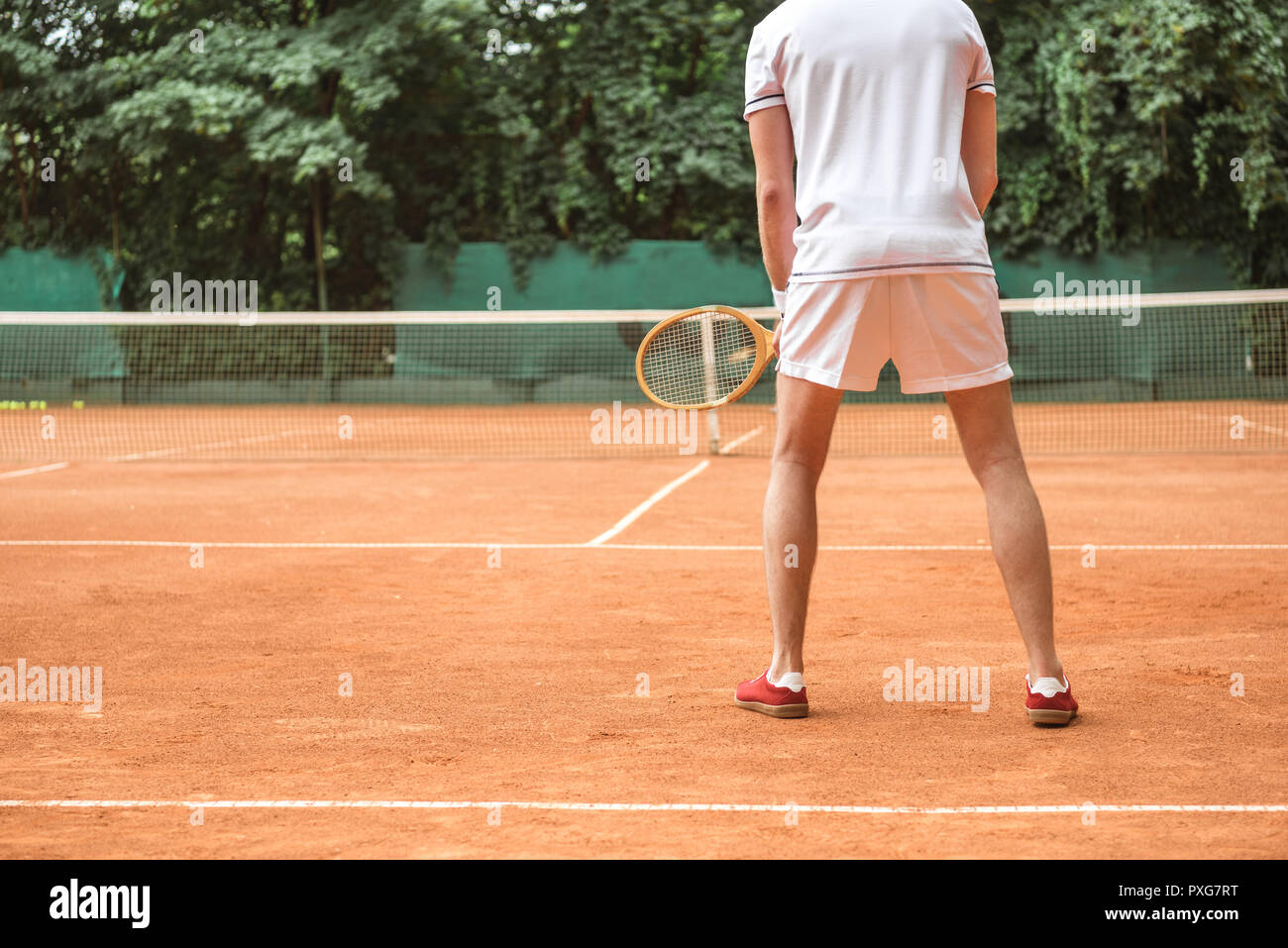 back view of tennis player with racket on tennis court with net Stock ...