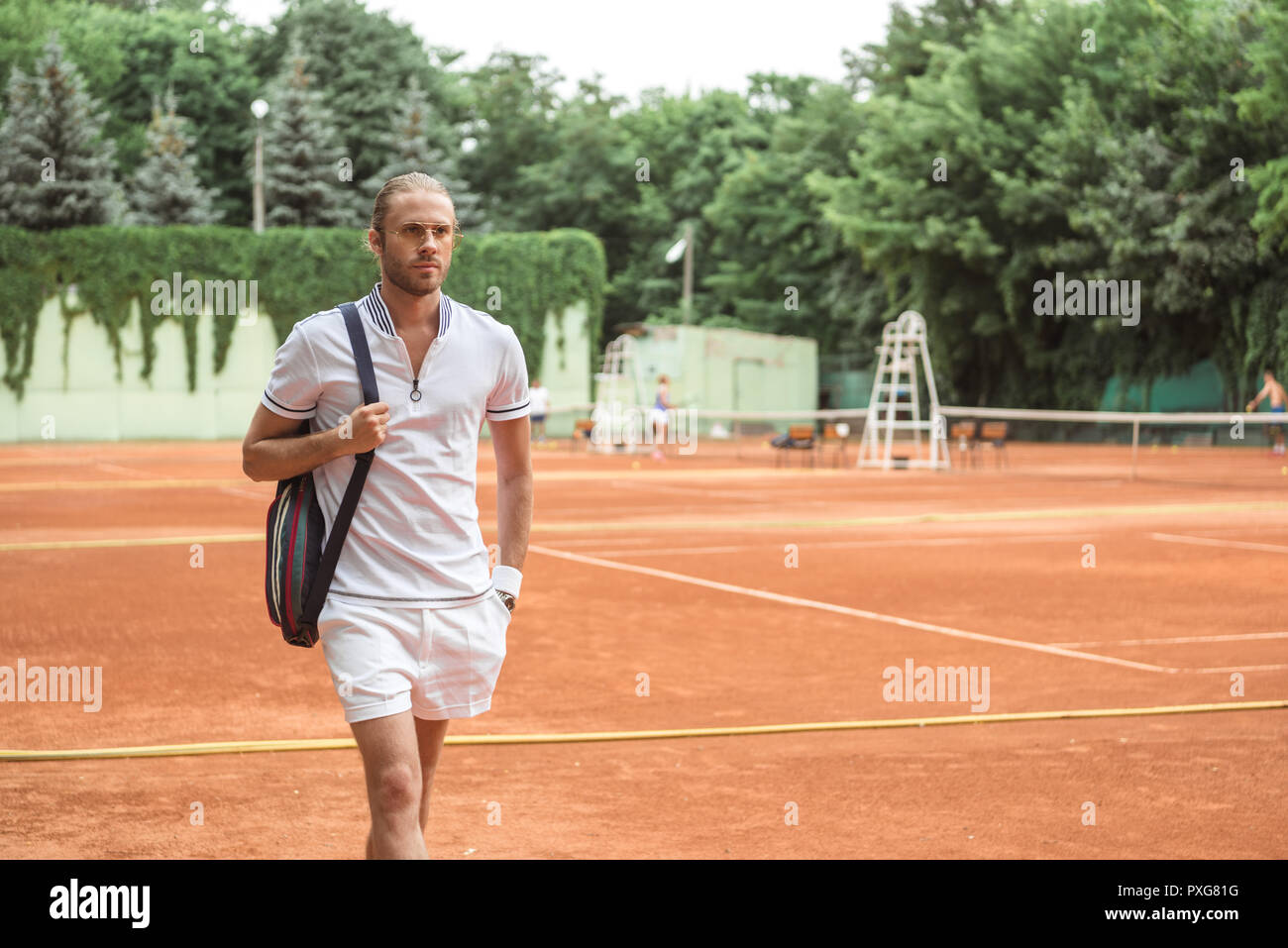 handsome tennis player after training on brown tennis court Stock Photo ...