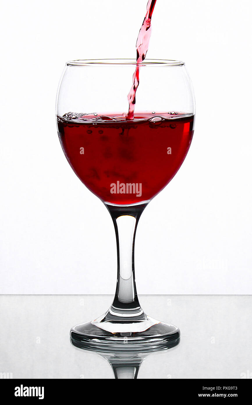 Splash of wine in a wineglass on a white background Stock Photo - Alamy