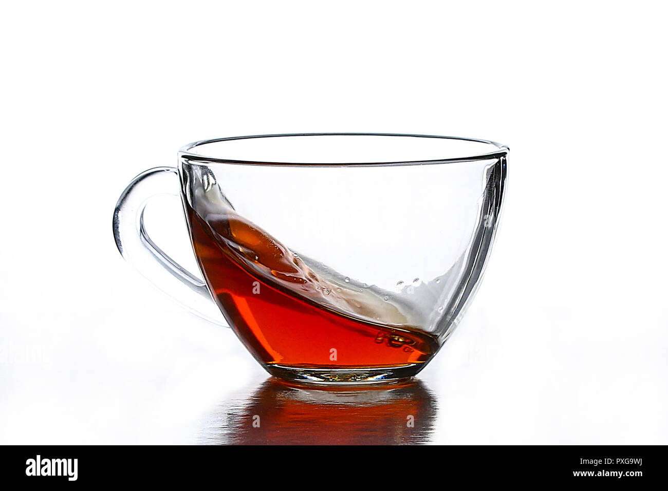 A splash of tea in a glass tea cup on a white background Stock Photo ...