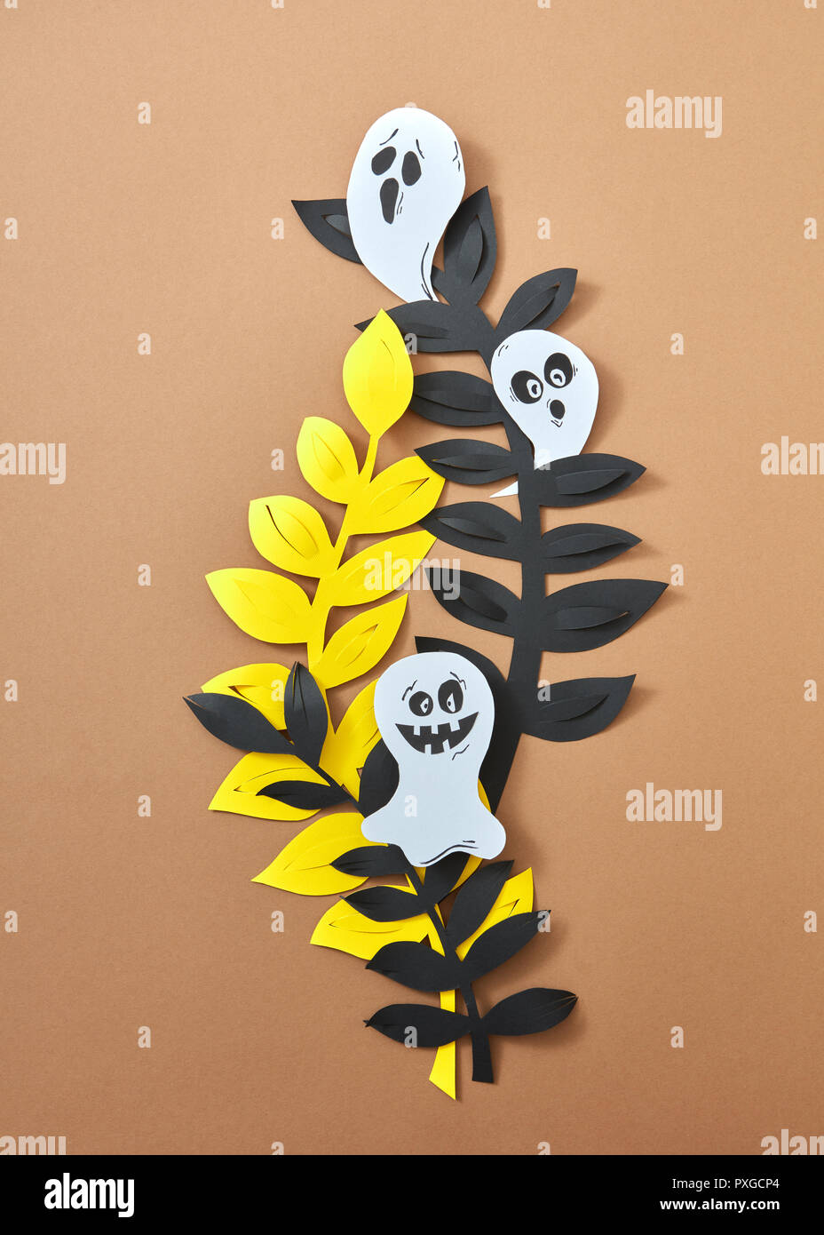 Handcraft paper composition of yellow, black leaves and ghosts on a ...