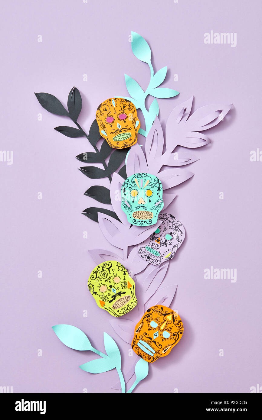 Handmade craft composition of multi-colored paper leaves and Calaveras ...
