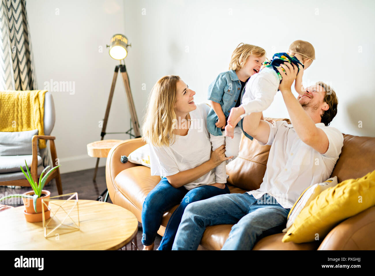 A family of four Family having fun on sofa Stock Photo - Alamy