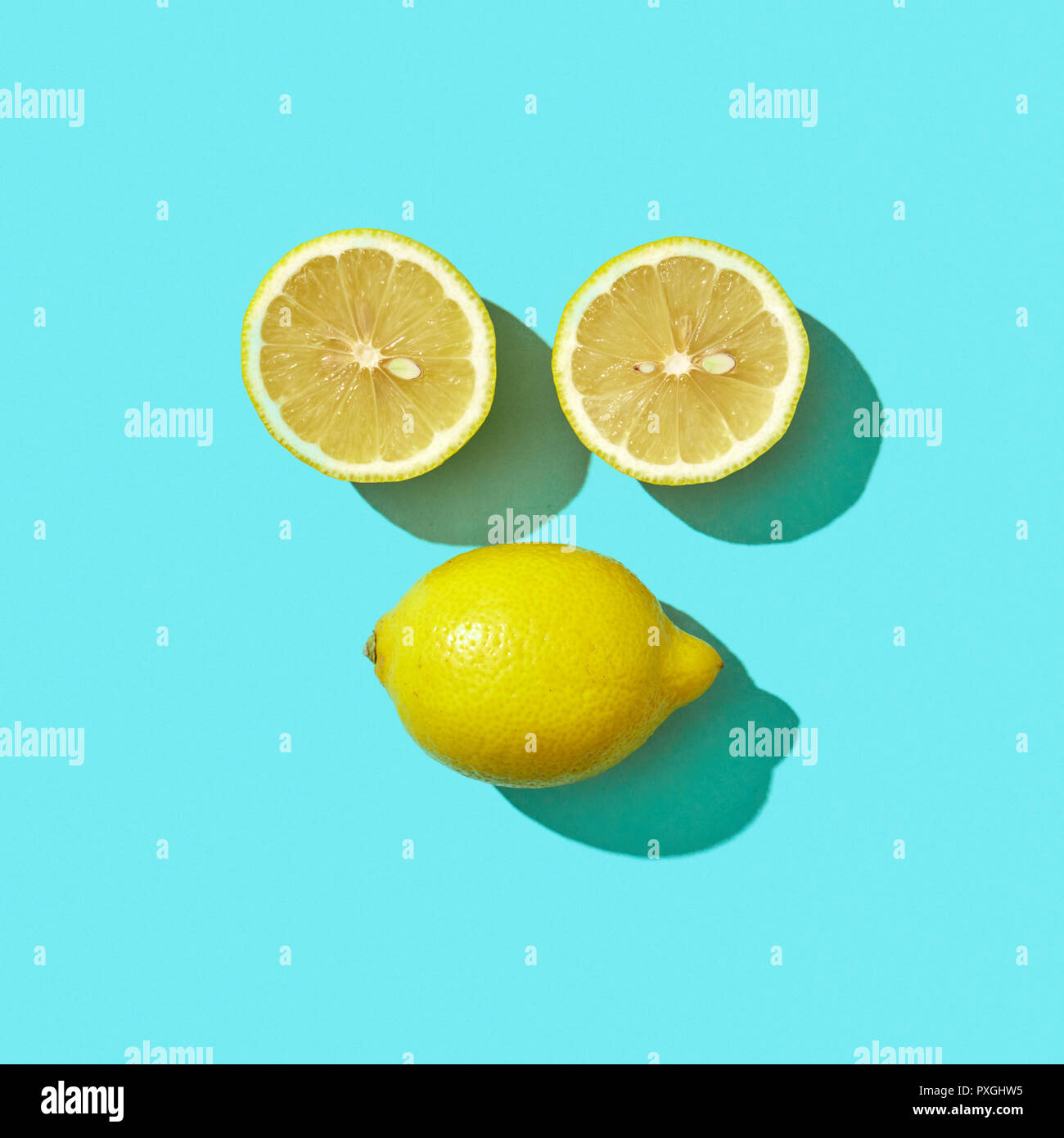 Two halves and a whole ripe lemon in the shape of a face with shadow ...