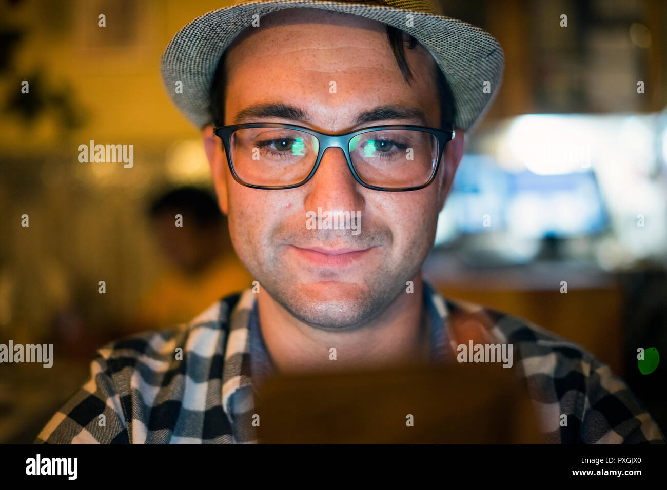 Young man using internet on his telephone in the restaurant at the ...
