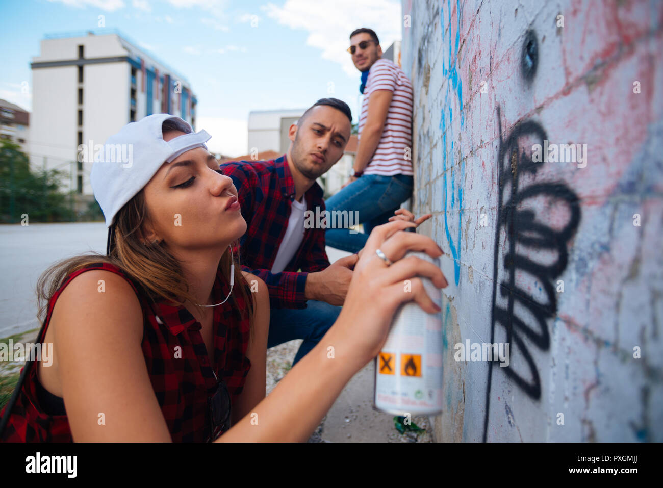 Rebel friends painting a graffiti Stock Photo - Alamy