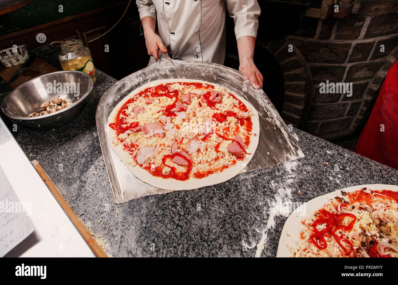 The chef is in the kitchen. Master class for pizza making. Pizza with ...