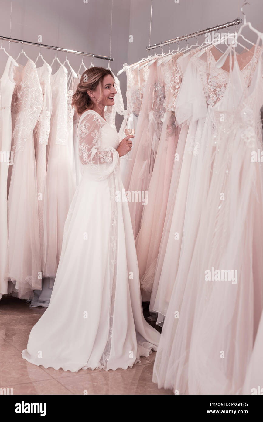 Joyful beautiful woman standing near wedding dresses Stock Photo - Alamy Joyful beautiful woman standing near wedding dresses Stock Photo - Alamy