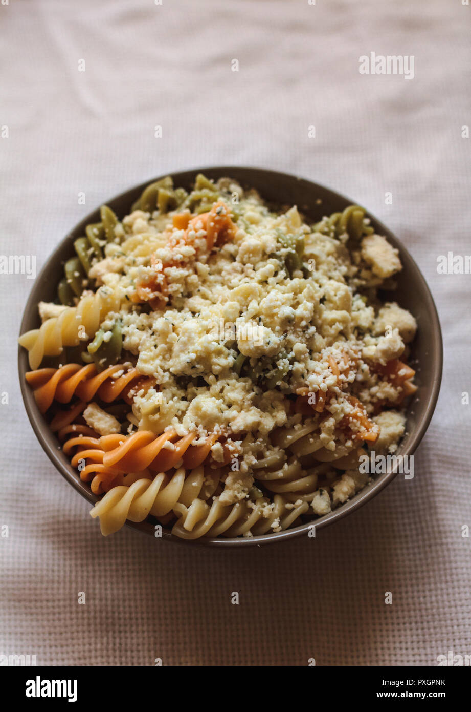 Tri color fusilli with cheese with dill in a grey bowl Stock Photo - Alamy
