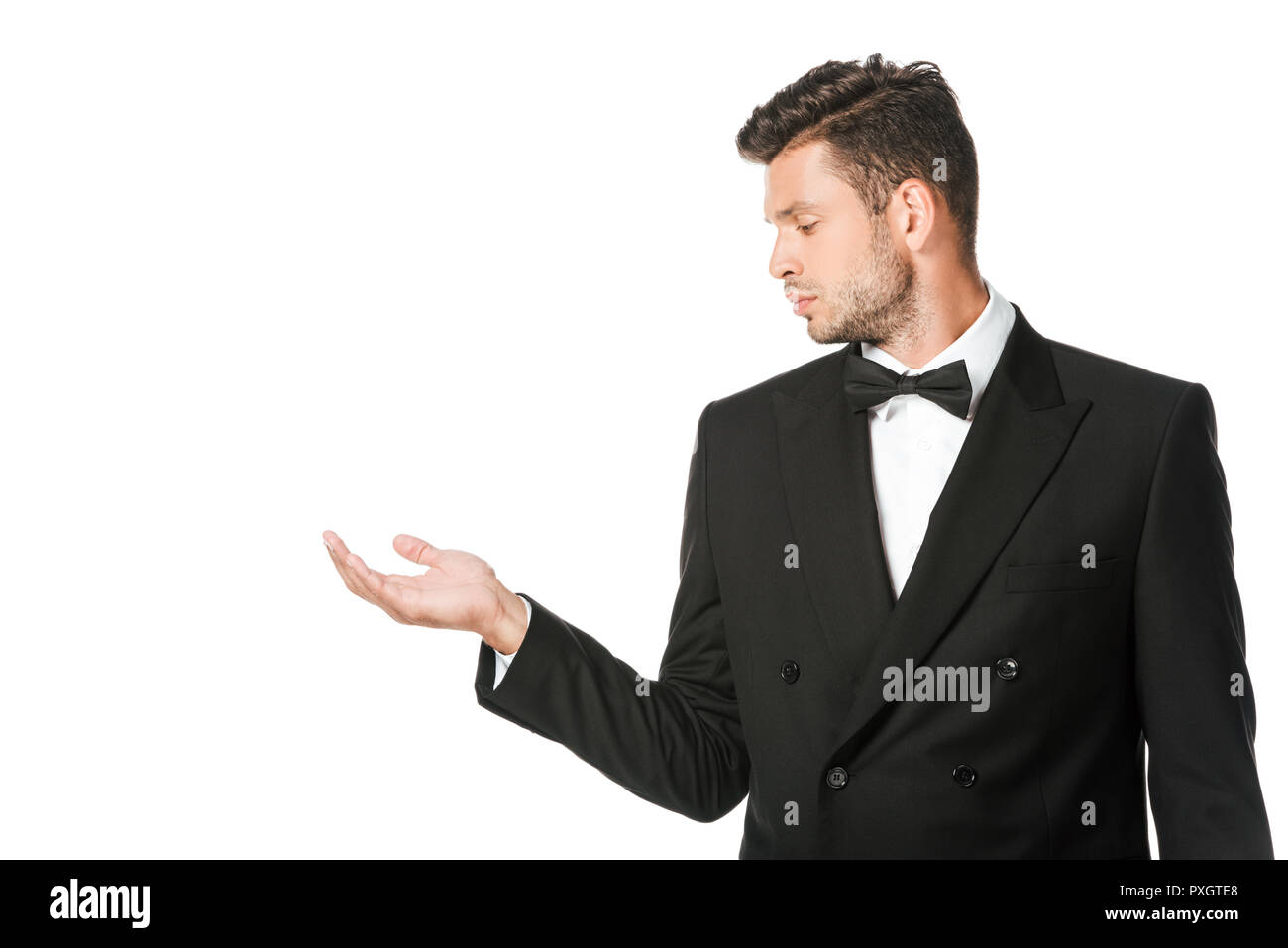 serious young man in suit looking at empty hand isolated on white Stock ...
