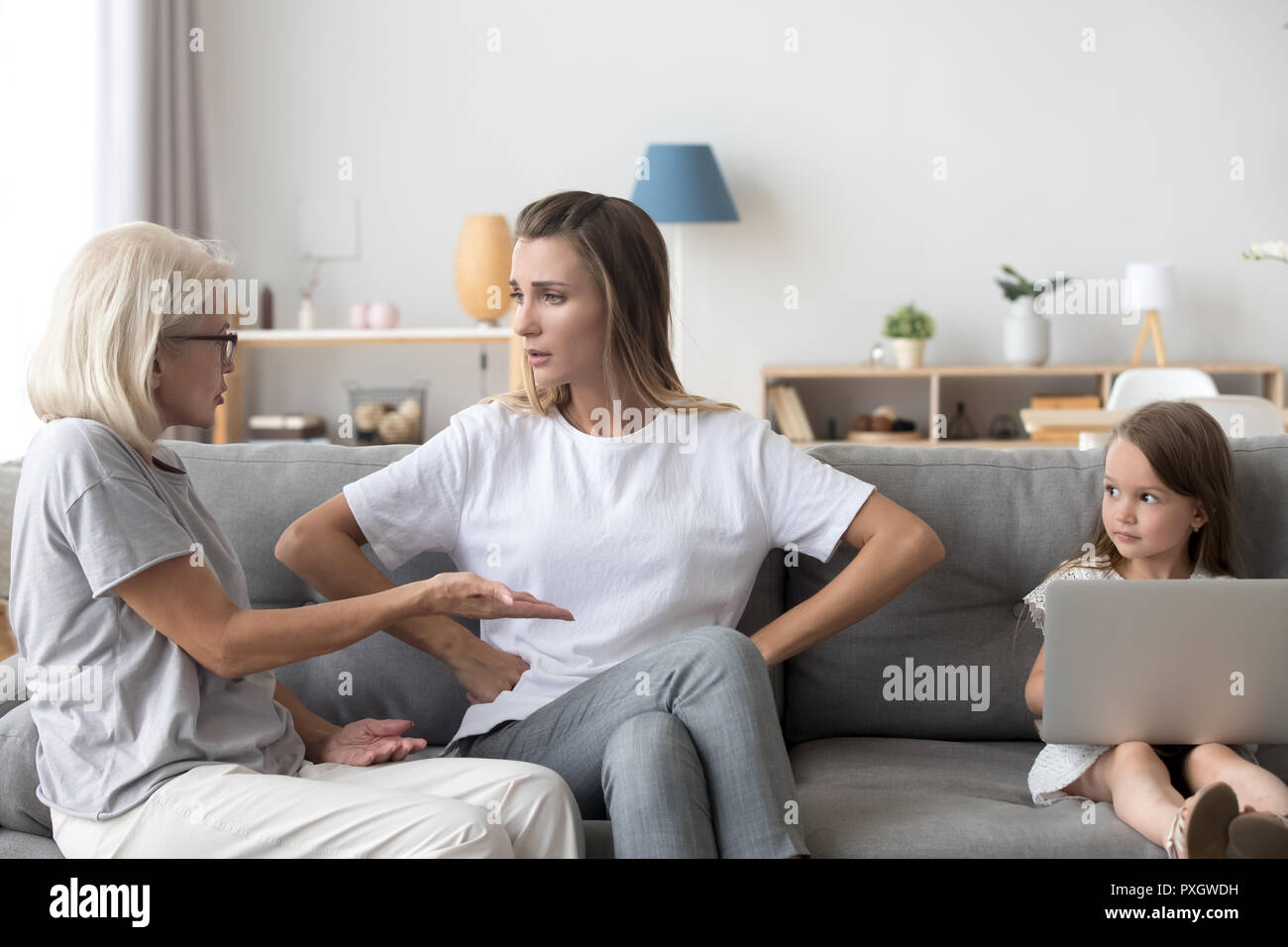 Small girl witness mother and grandmother arguing at home Stock Photo ...