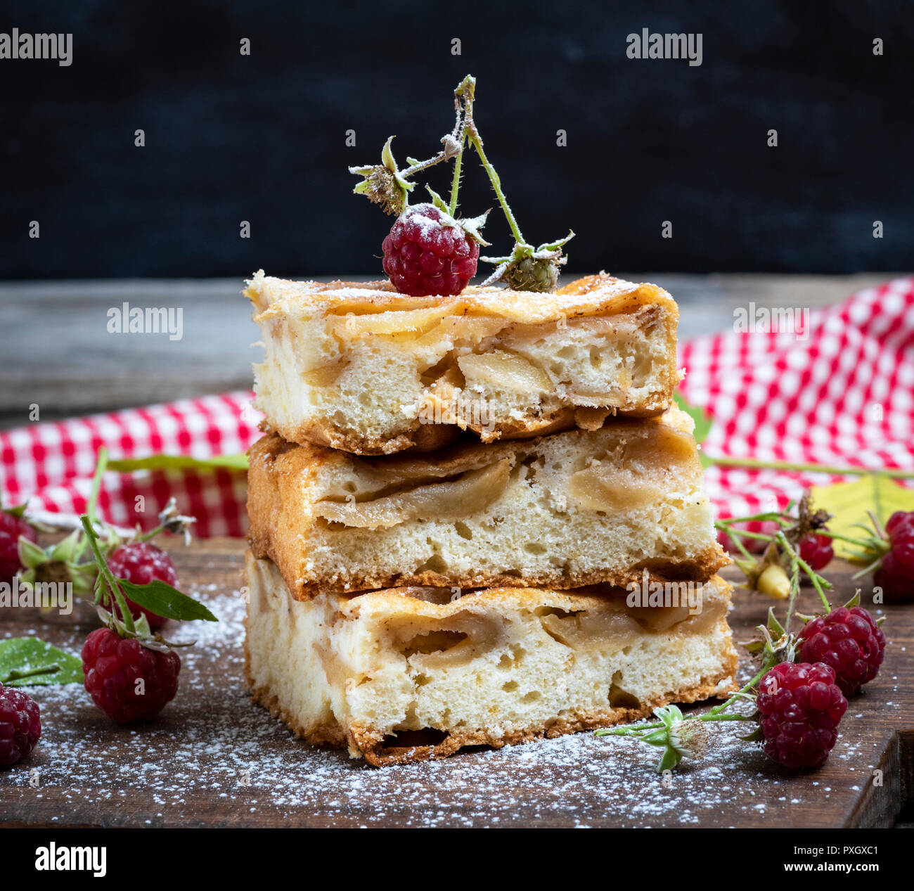 baked square pieces of apple pie are stacked on a brown wooden board ...