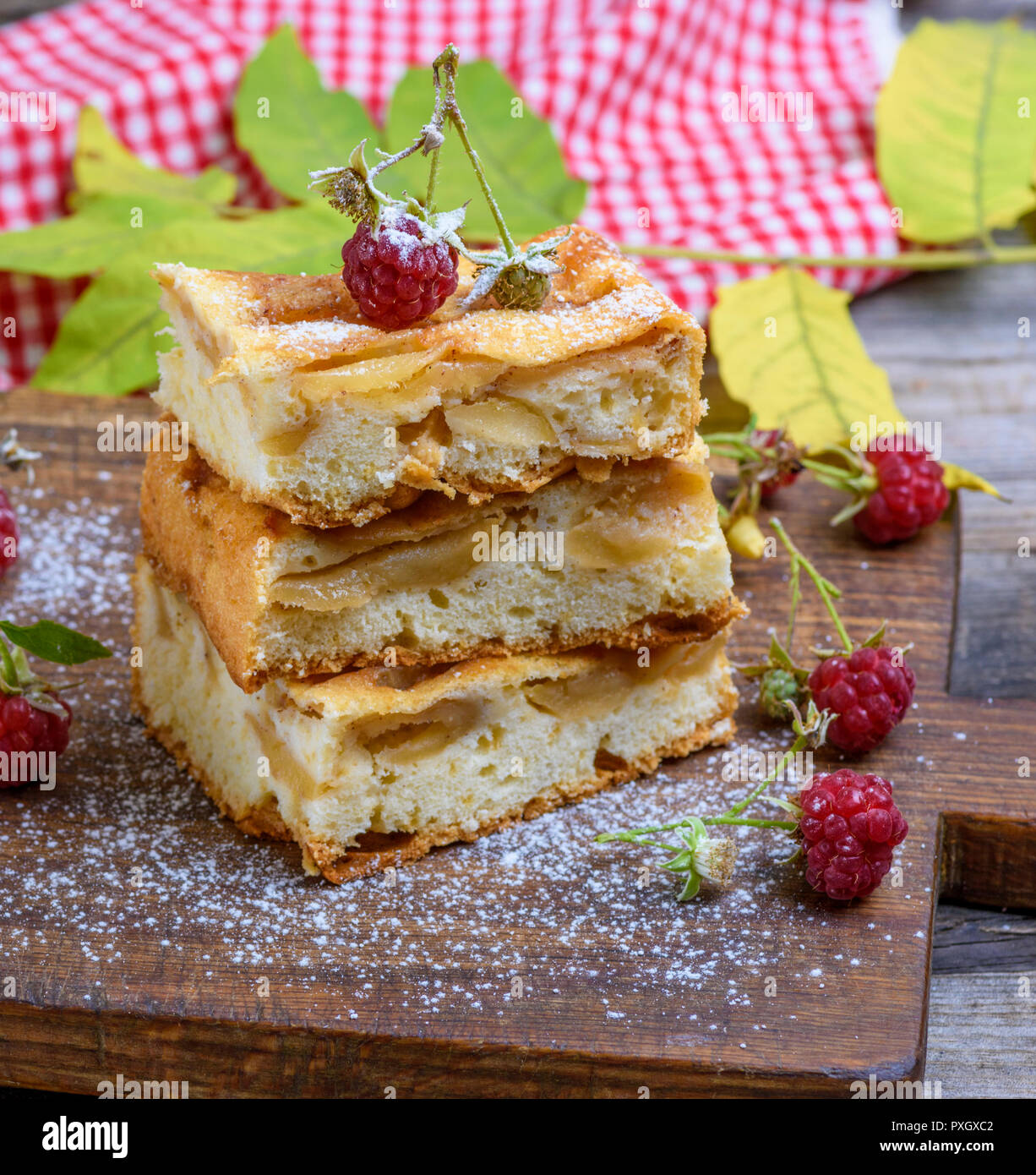 baked square pieces of apple pie are stacked on a brown wooden board ...