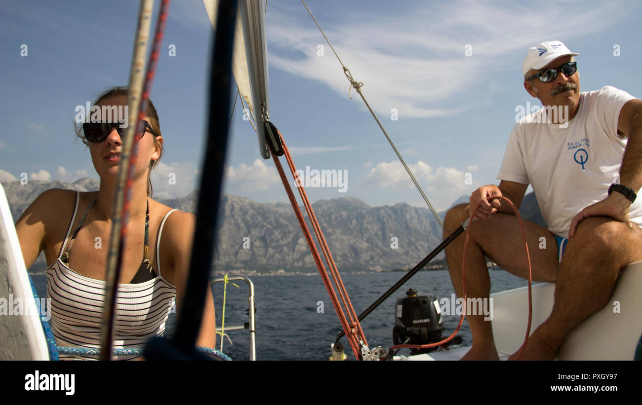 Montenegro, September 2018 - A young woman and skipper in a sailboat ...
