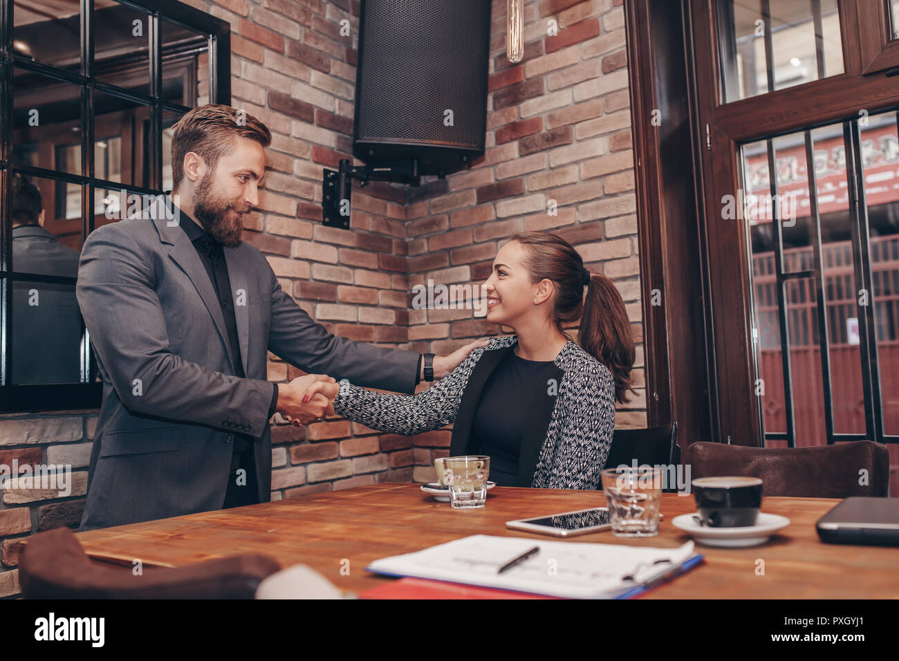 Happy young candidate shaking hands with her employer after a job ...