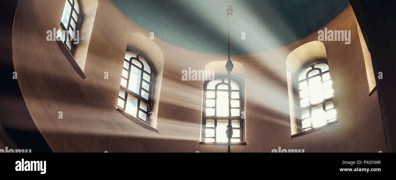 Sun rays make their way through the high vaulted arched window under ...