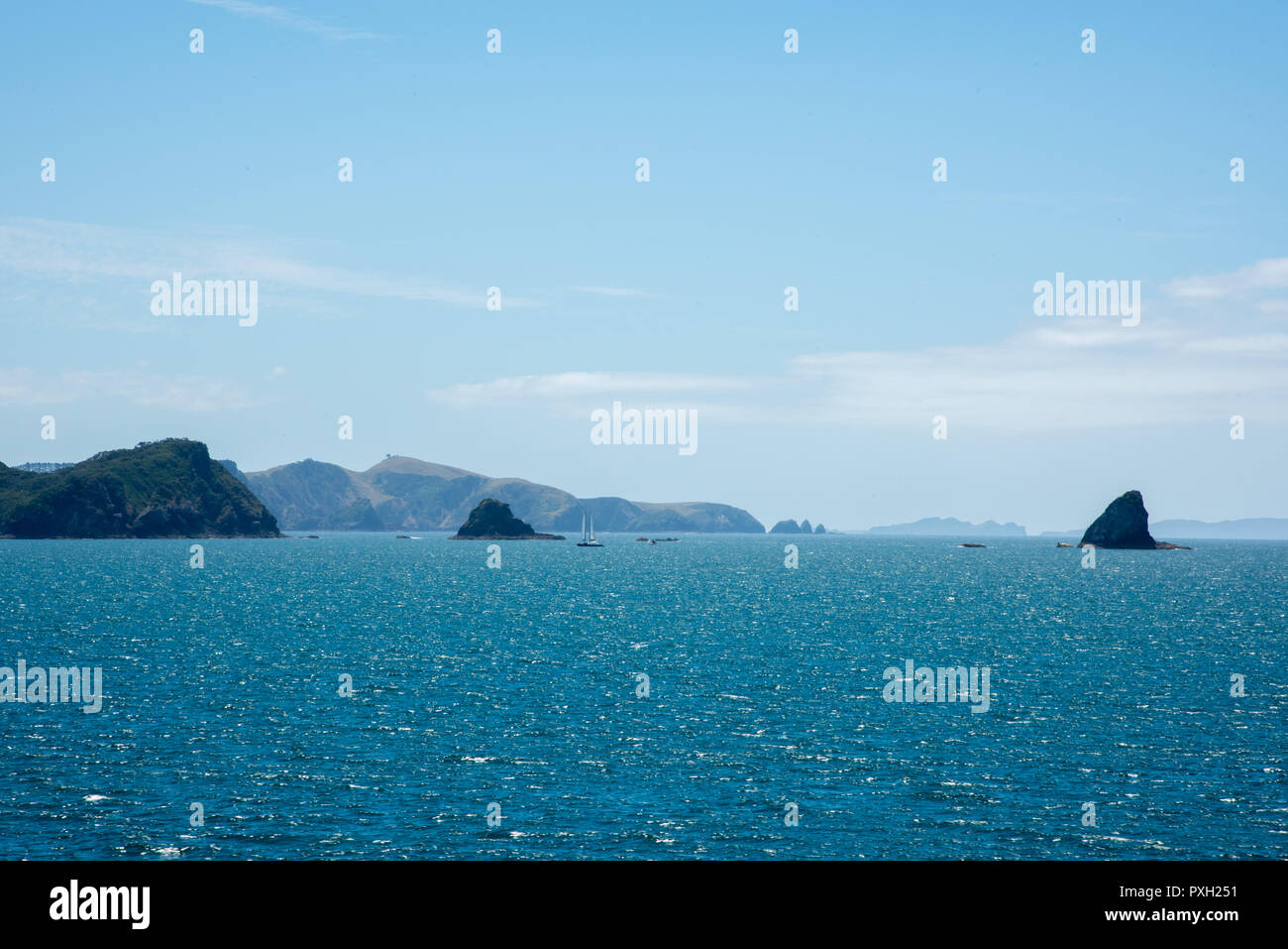 Stunning island coastline with glistening Tasman Sea waters under a ...