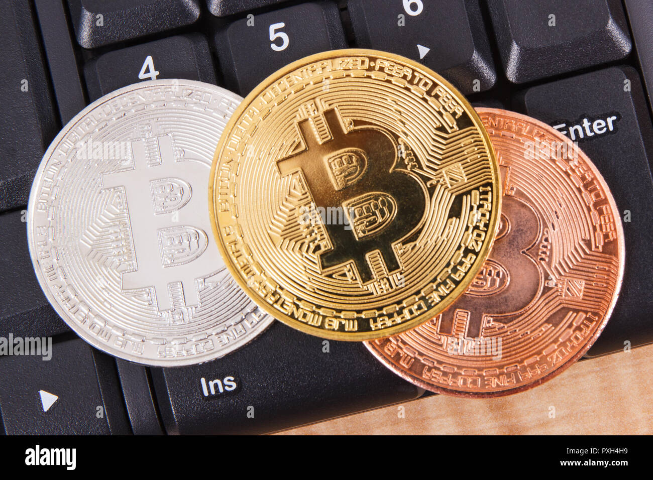 Bitcoins on compuer keyboard in background, symbol of electronic ...