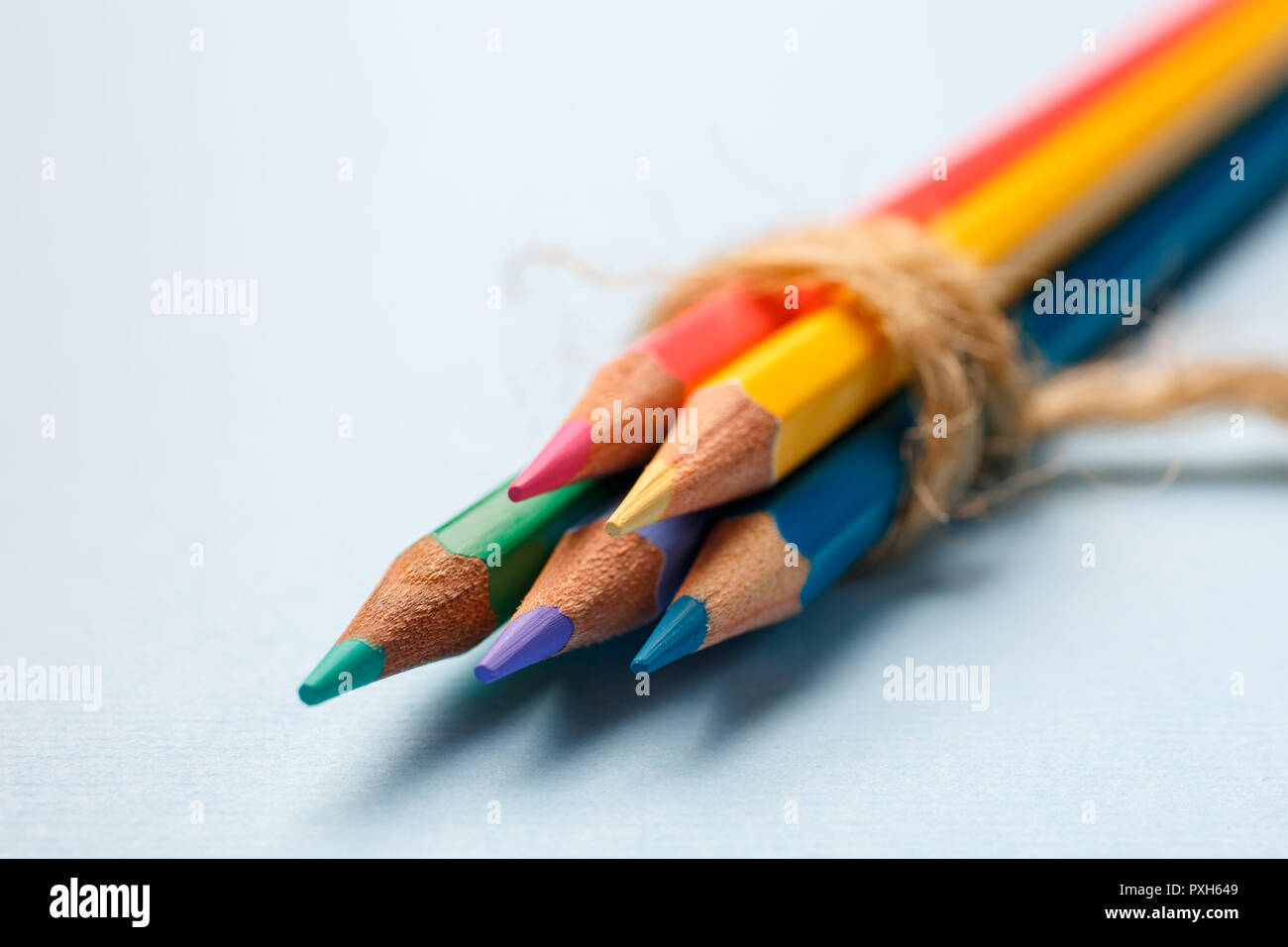 Five bright wooden crayons lie on a blue background Stock Photo - Alamy