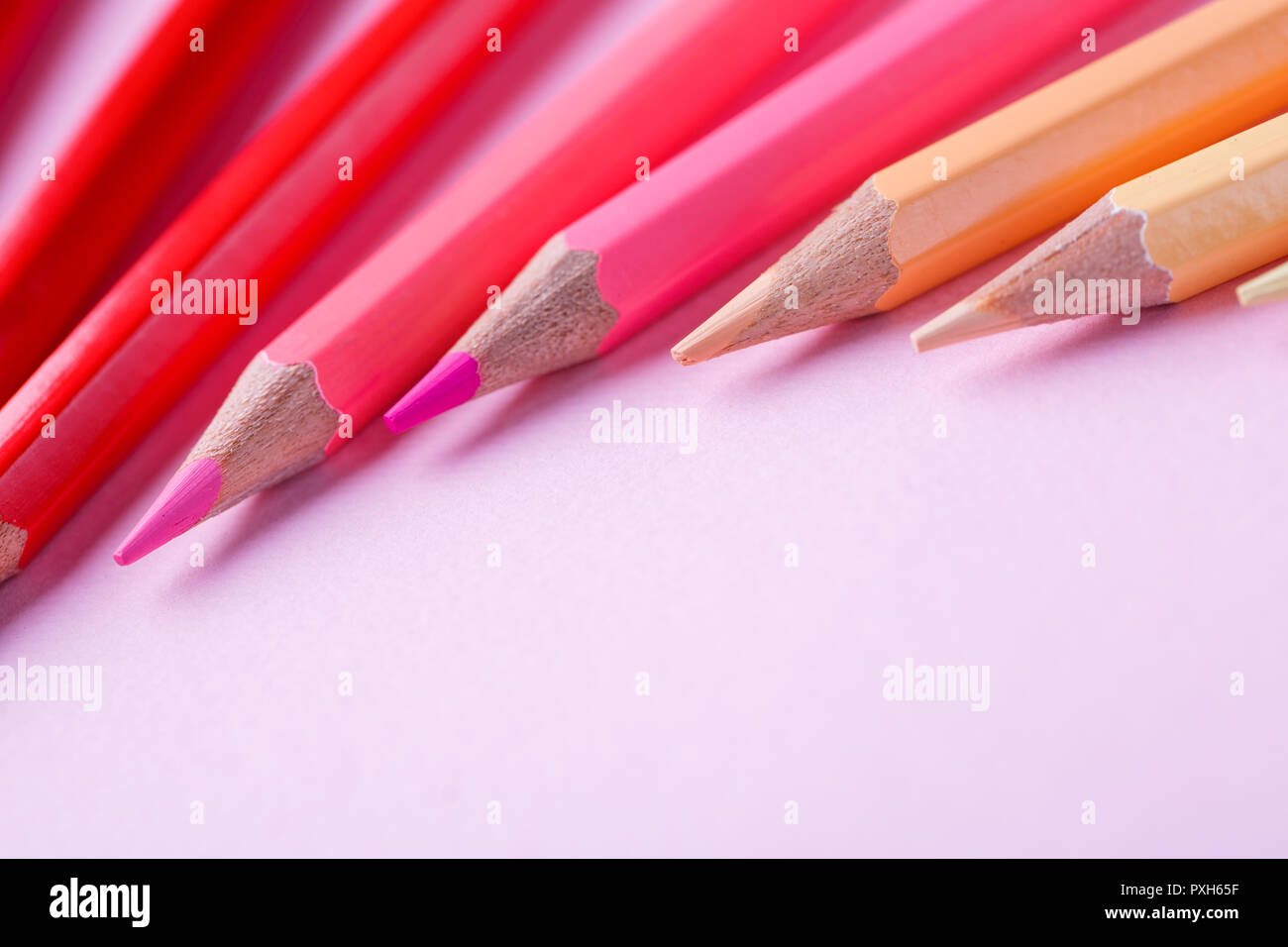 Color pencils lying on pastel pink background Stock Photo - Alamy