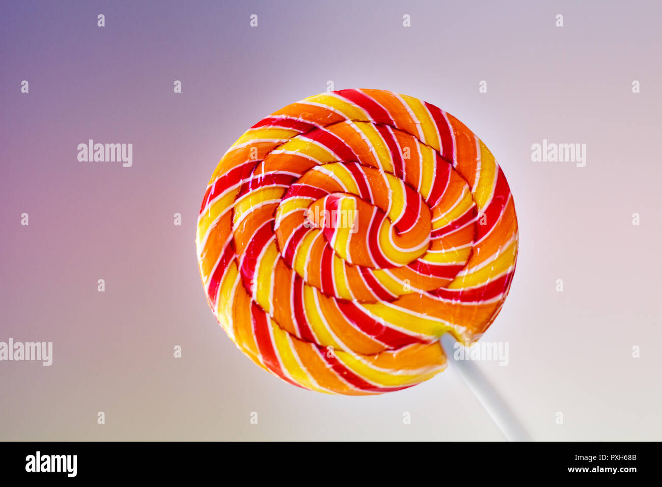yellow-red lollipop on a multi-colored background Stock Photo - Alamy