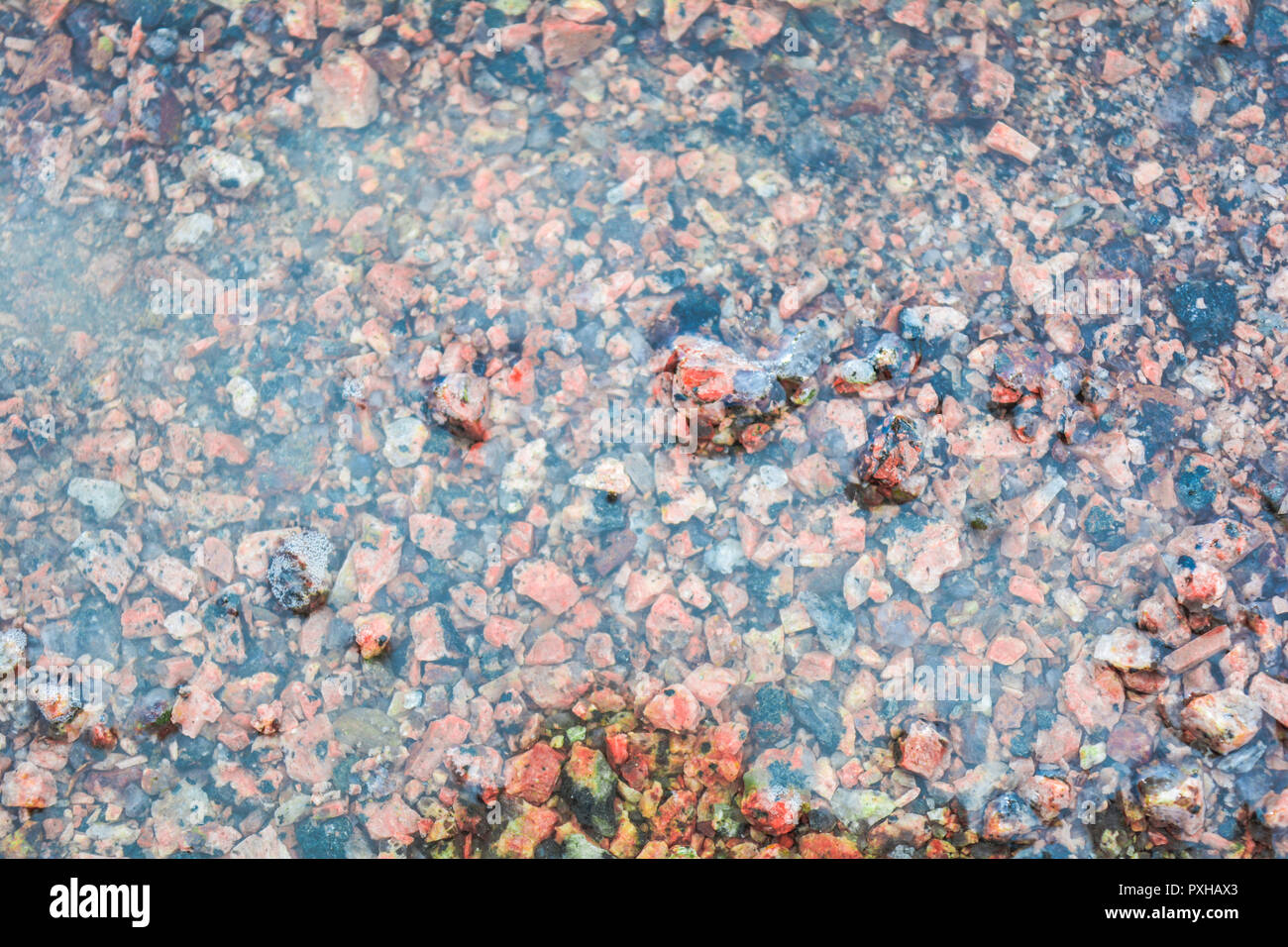 Brown texture of wet red granite Gravel. Sand and stones in water on ...