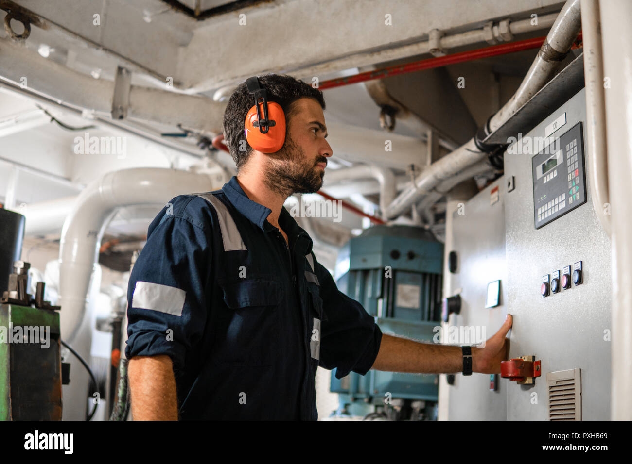 Marine engineer officer working in engine room Stock Photo - Alamy