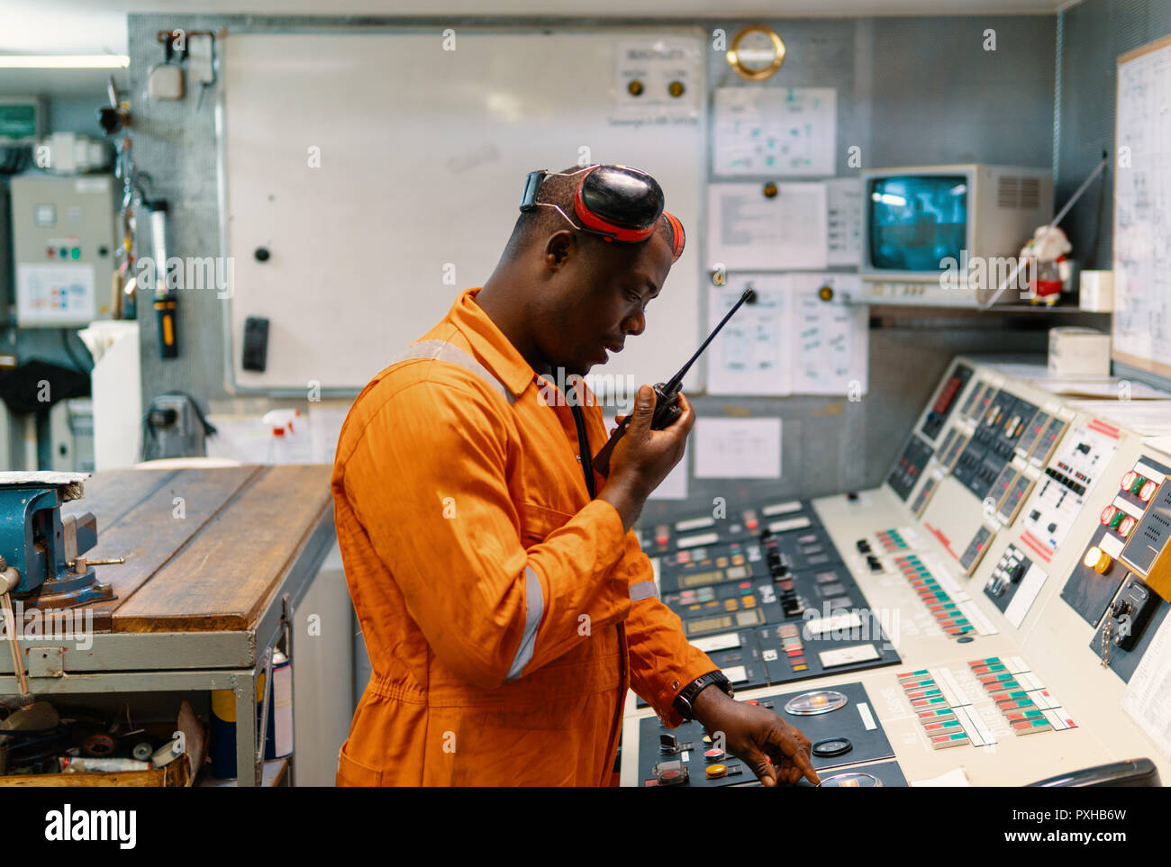 Marine engineer officer working in engine room Stock Photo - Alamy