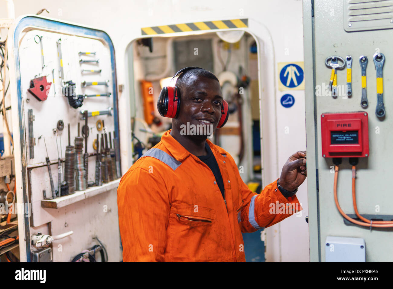 Marine engineer officer working in engine room Stock Photo - Alamy