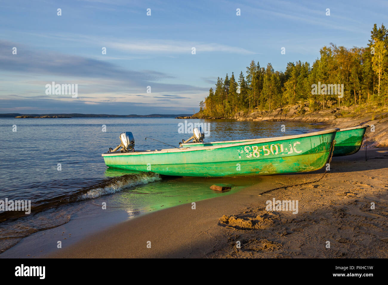 Blue Sky and Two Green Pella Boats at Lake Beach Stock Photo - Alamy