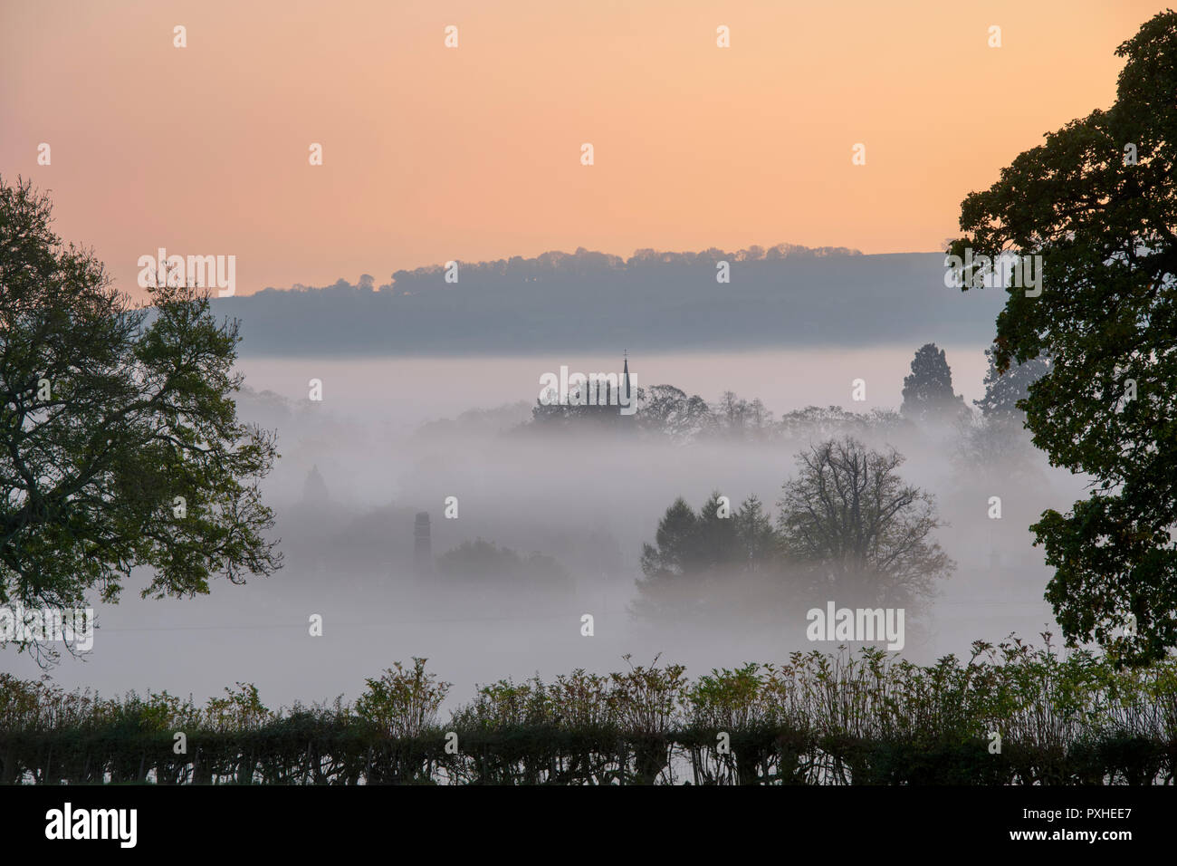 Mist and fog at sunrise rolling over the countryside around the ...
