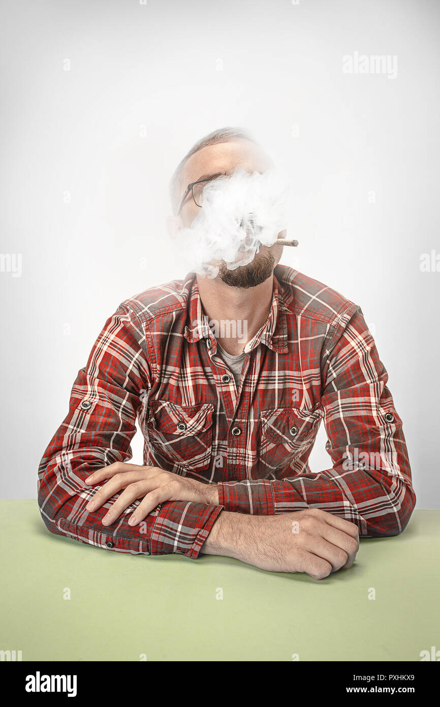Handsome young man sitting smoking hi-res stock photography and images ...