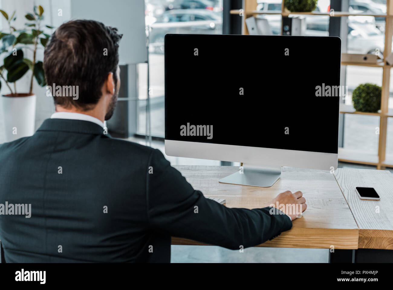 back view of businessman at workplace with computer screen with blank ...