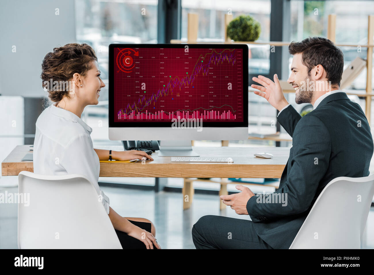 smiling business colleagues having conversation at workplace with ...