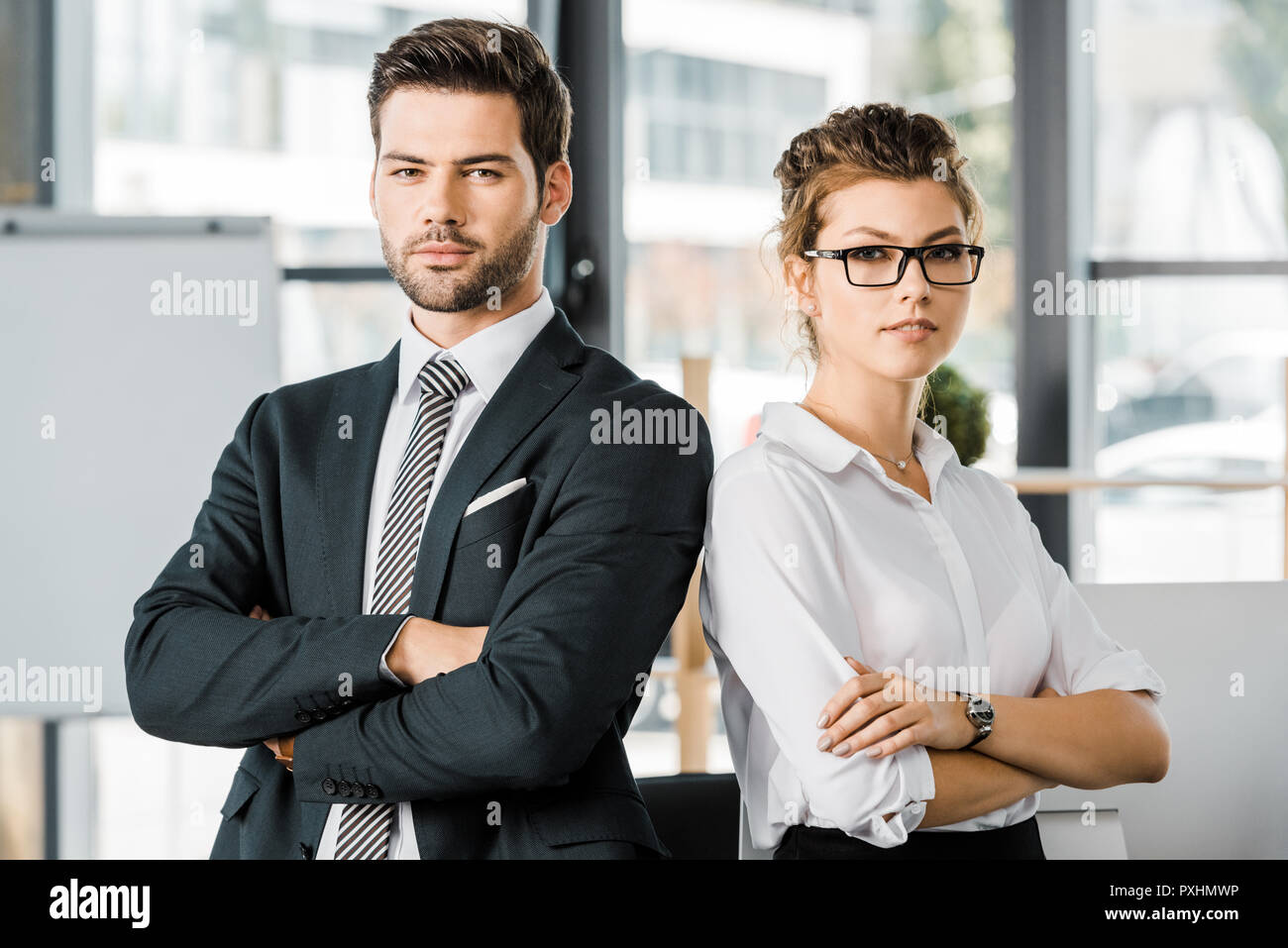 portrait of confident business people in formal wear with arms crossed ...