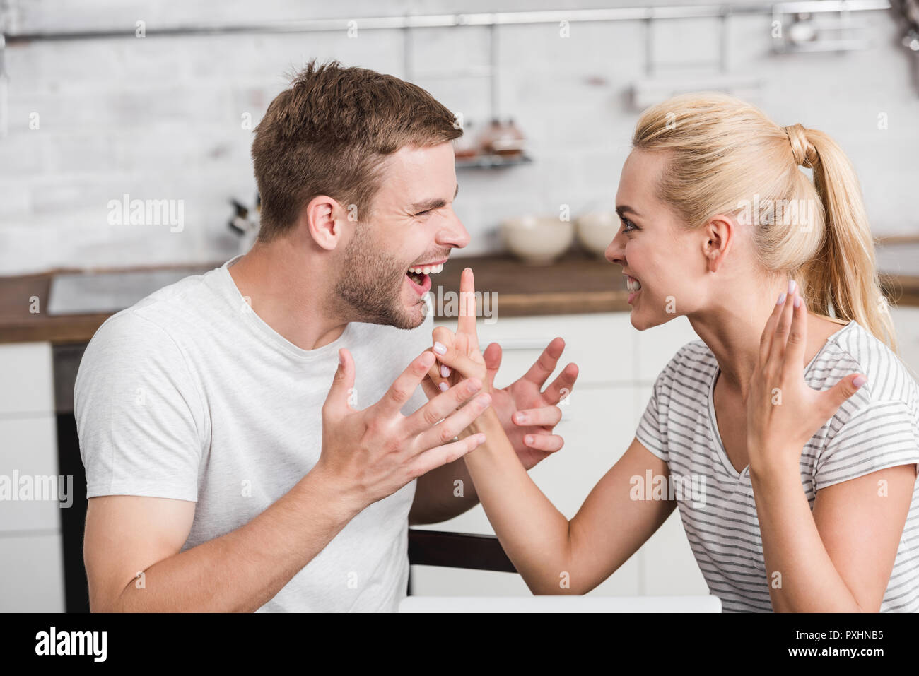 side view of emotional young couple arguing and looking at each other ...